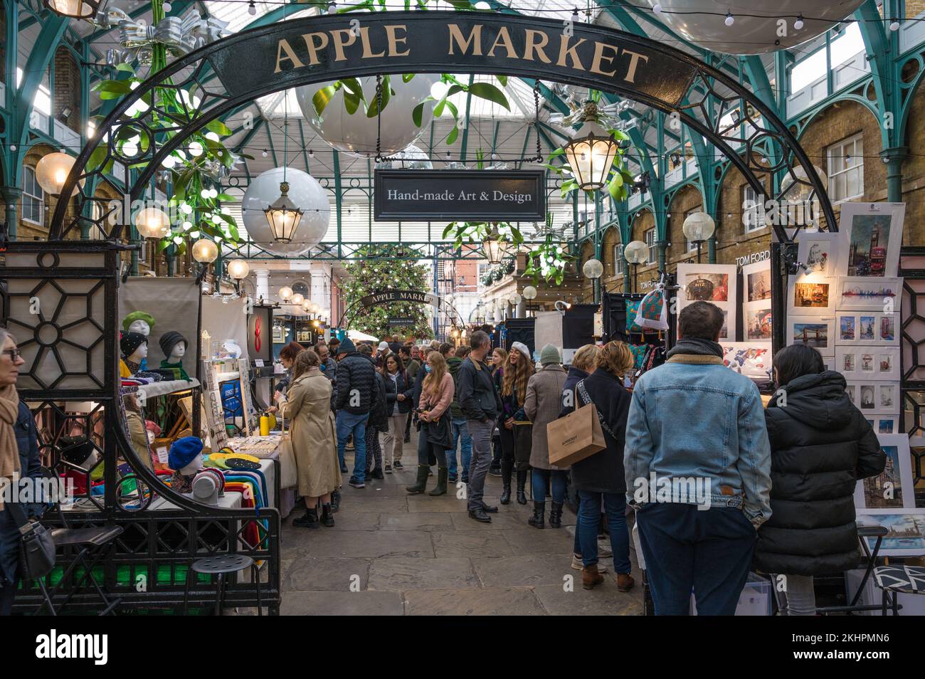 People shopping in the Apple Market. Christmas decorations hang from ...