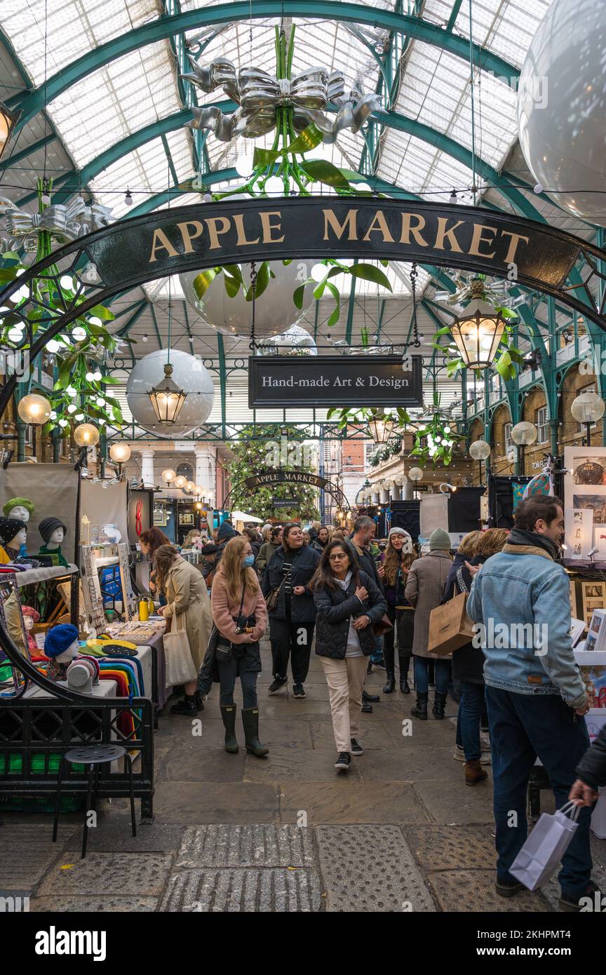 People shopping in the Apple Market. Christmas decorations hang from ...