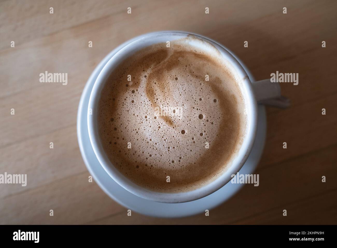 A closeup of the bubbles and froth floating on the surface of a cup of ...