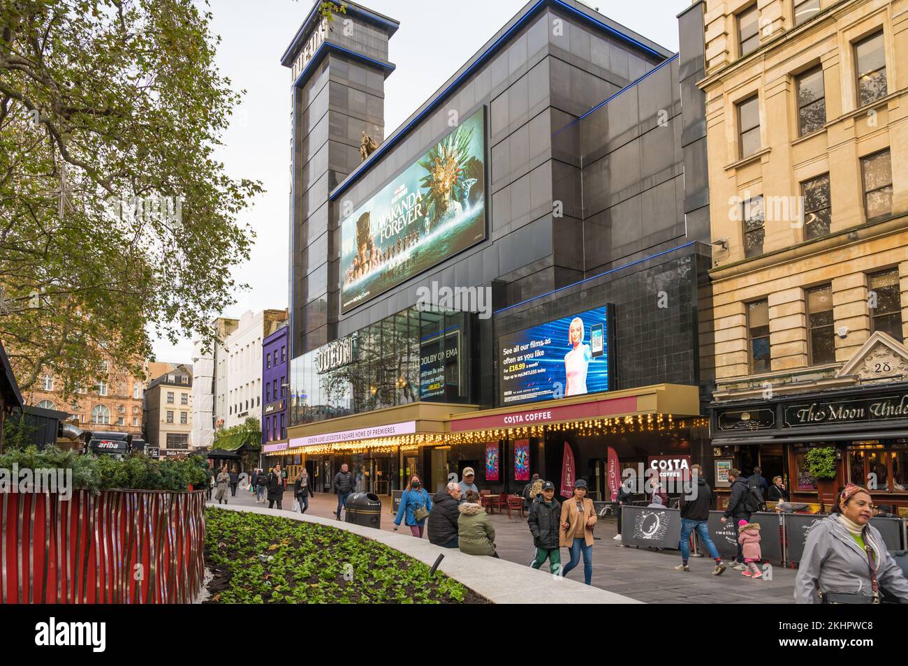 People out and about in Leicester Square pass by the Odeon Luxe cinema ...