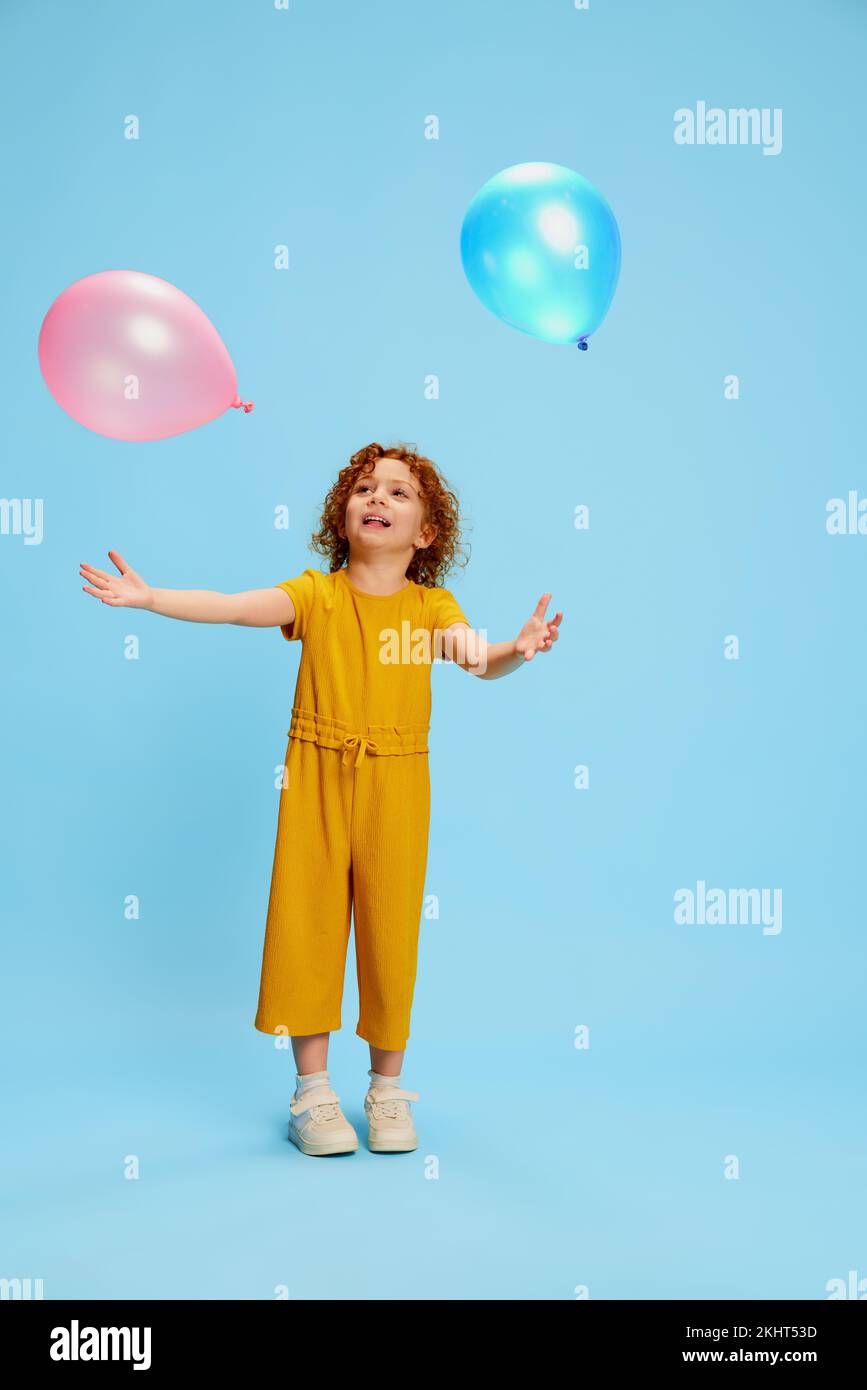 Portrait of cute little girl, child with curly red hair posing ...