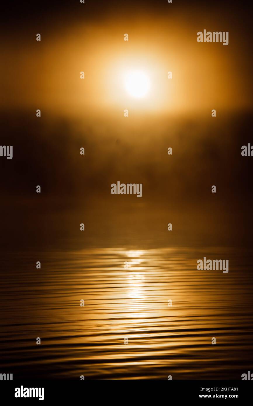 A vertical shot of a beautiful sunset visible on the horizon of a beach ...
