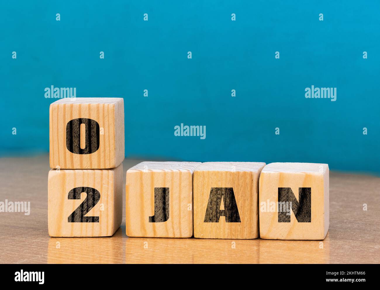 Cube shape calendar for January 02 on wooden surface with empty space ...