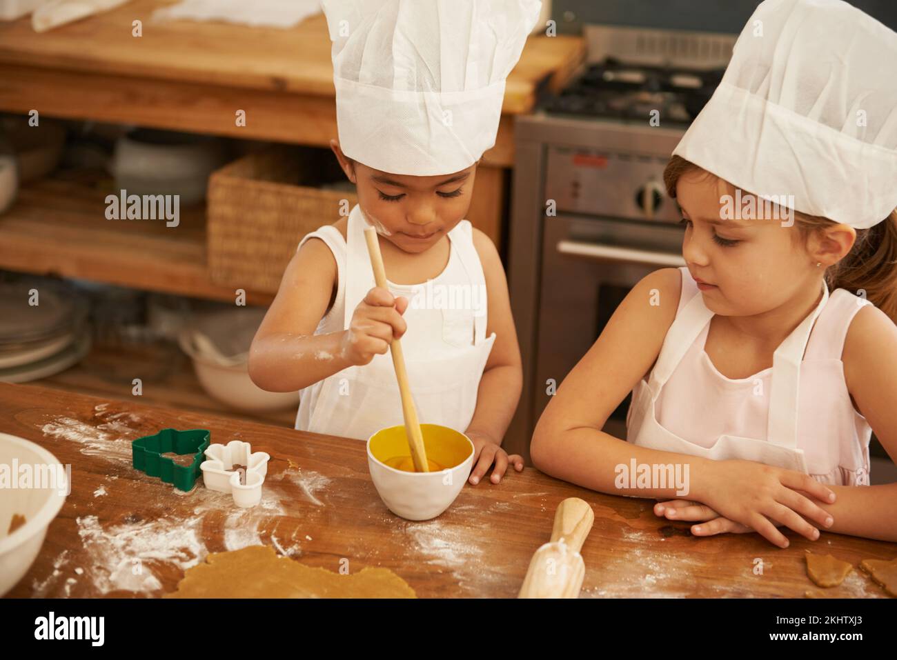 Children, learning and baking in a kitchen with girls bonding, curious ...