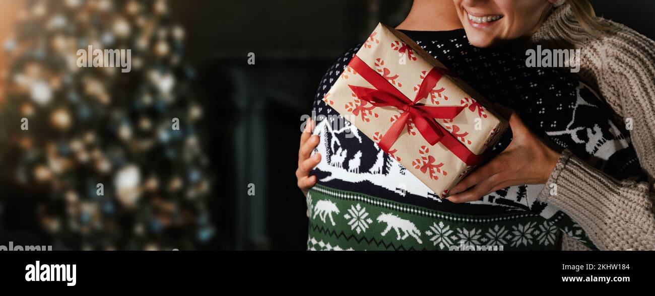 woman giving a thankful hug to her husband after receiving a gift box ...