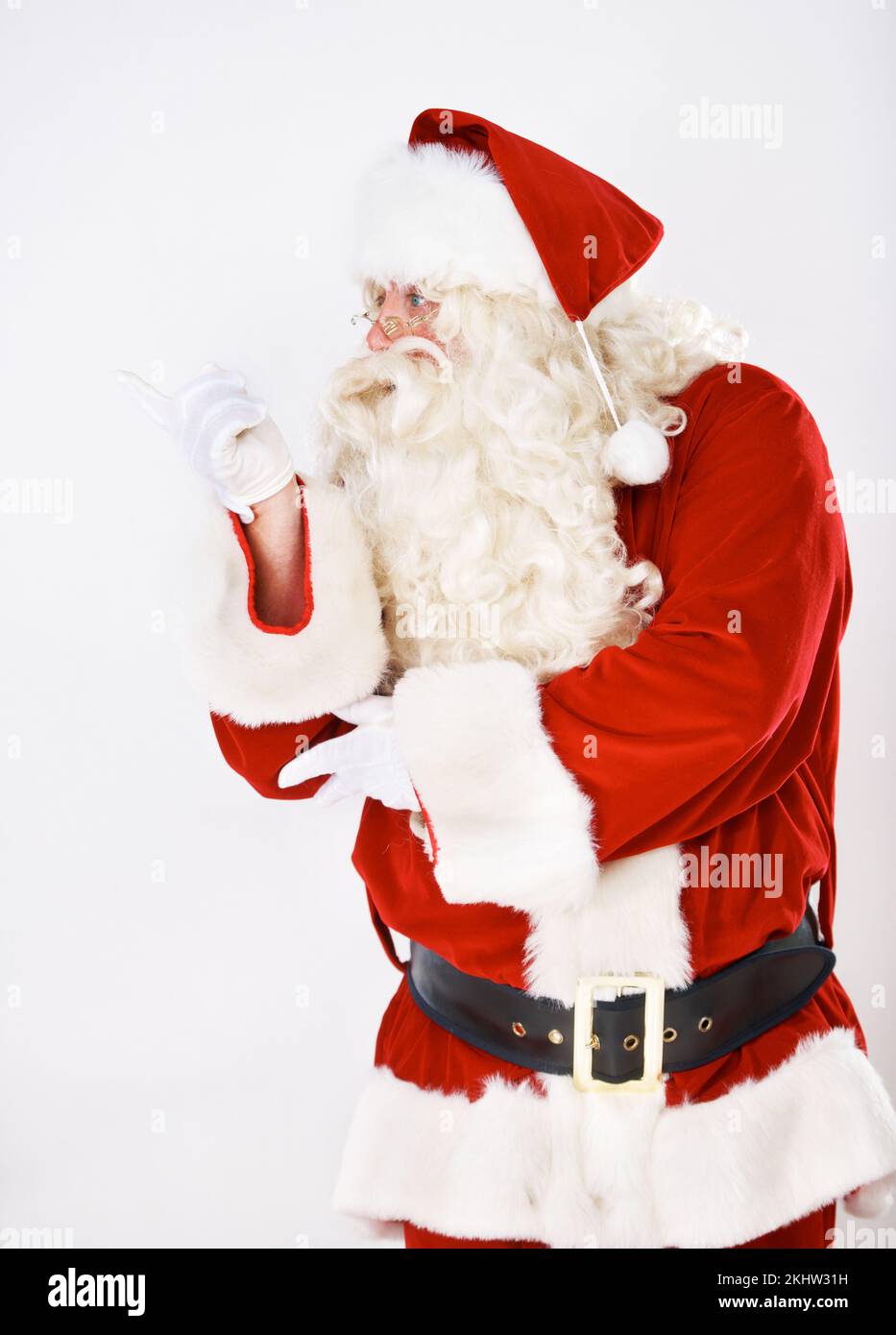 Father Christmas in studio pointing to white background for marketing ...