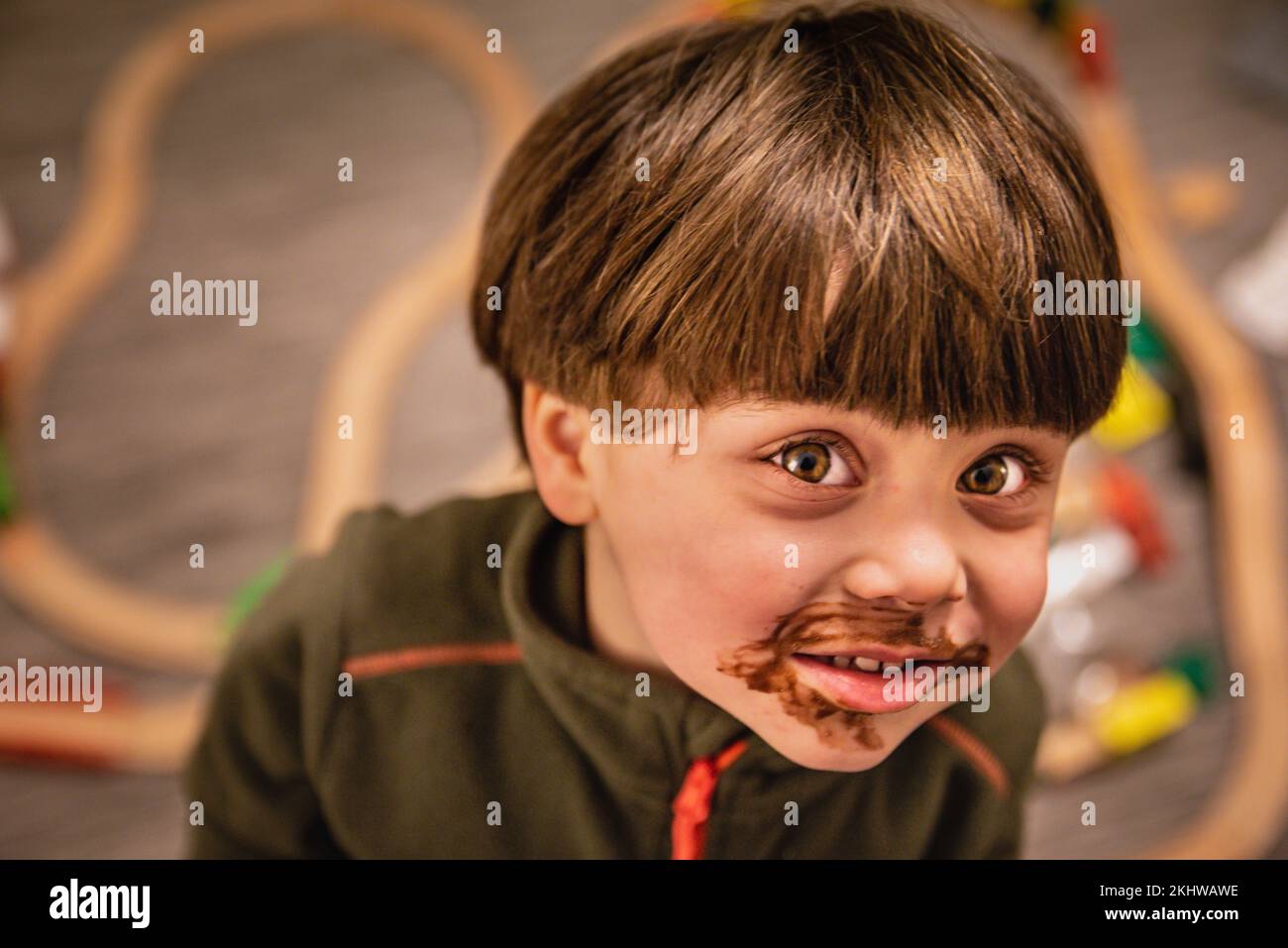 Happy smile of a curious boy with chocolate on his mouth. Child has ...