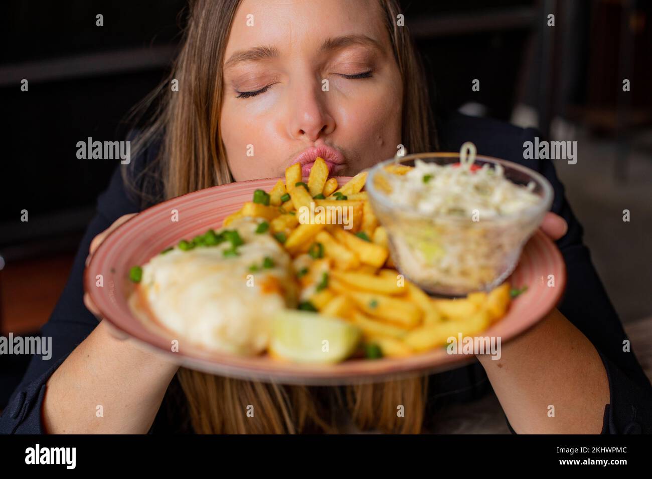 Satisfied Delightful Woman With Close Eyes Joy Smell Tasty Plate Of Food In Hands Show To
