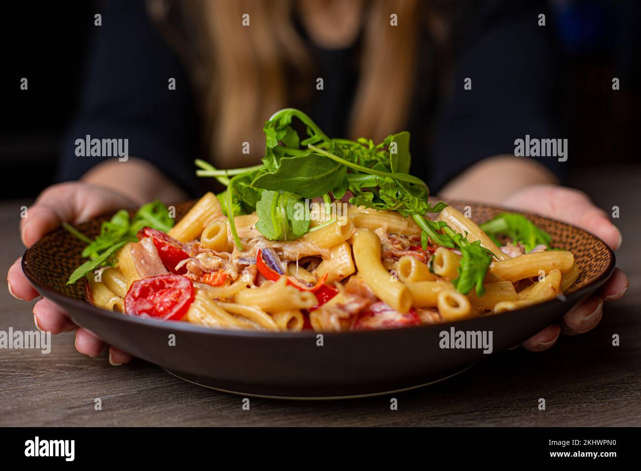 Unrecognizable, cropped woman in black outfit holding juicy, ready to ...