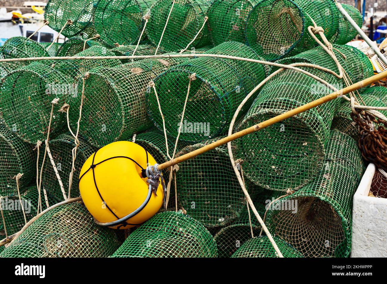 Stack of green fish traps and yellow float at harbor Stock Photo - Alamy
