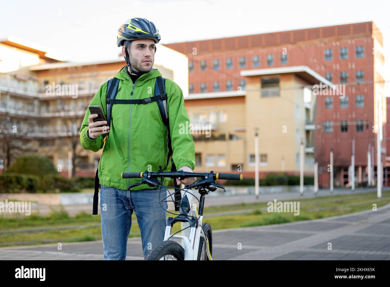 Delivery man looking for address, young rider using mobile application ...