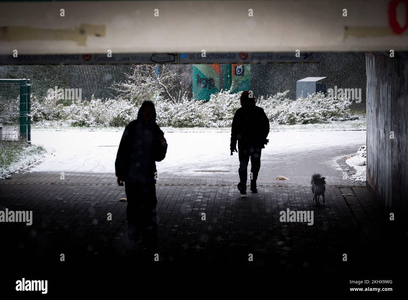 People and a dog are seen walking underneath an underpass in Warsaw ...