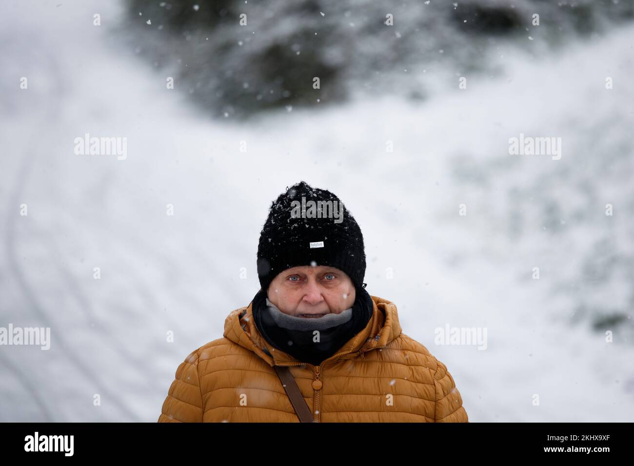 A woman wearing a hat is seen walking while snow falls in Warsaw ...