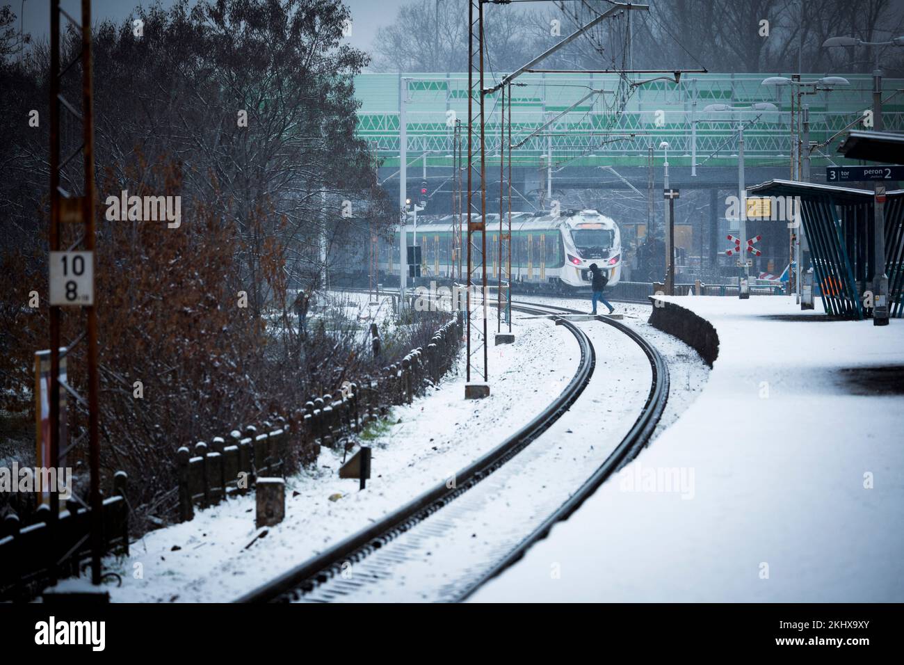 A man is seen crossing a train track with an oncoming train in the ...
