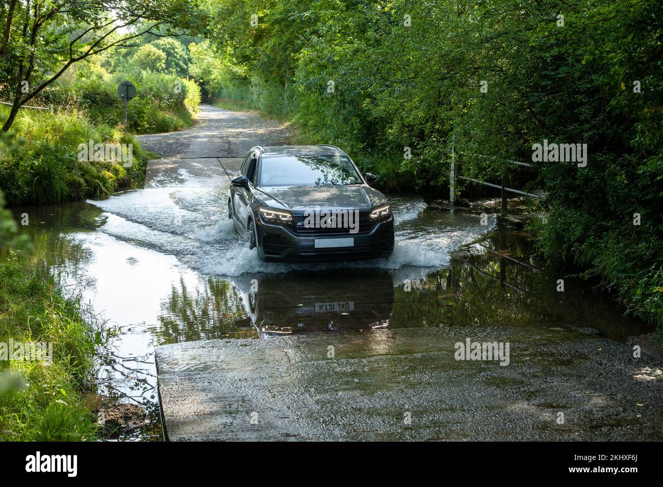 a family car driving through a ford Stock Photo - Alamy