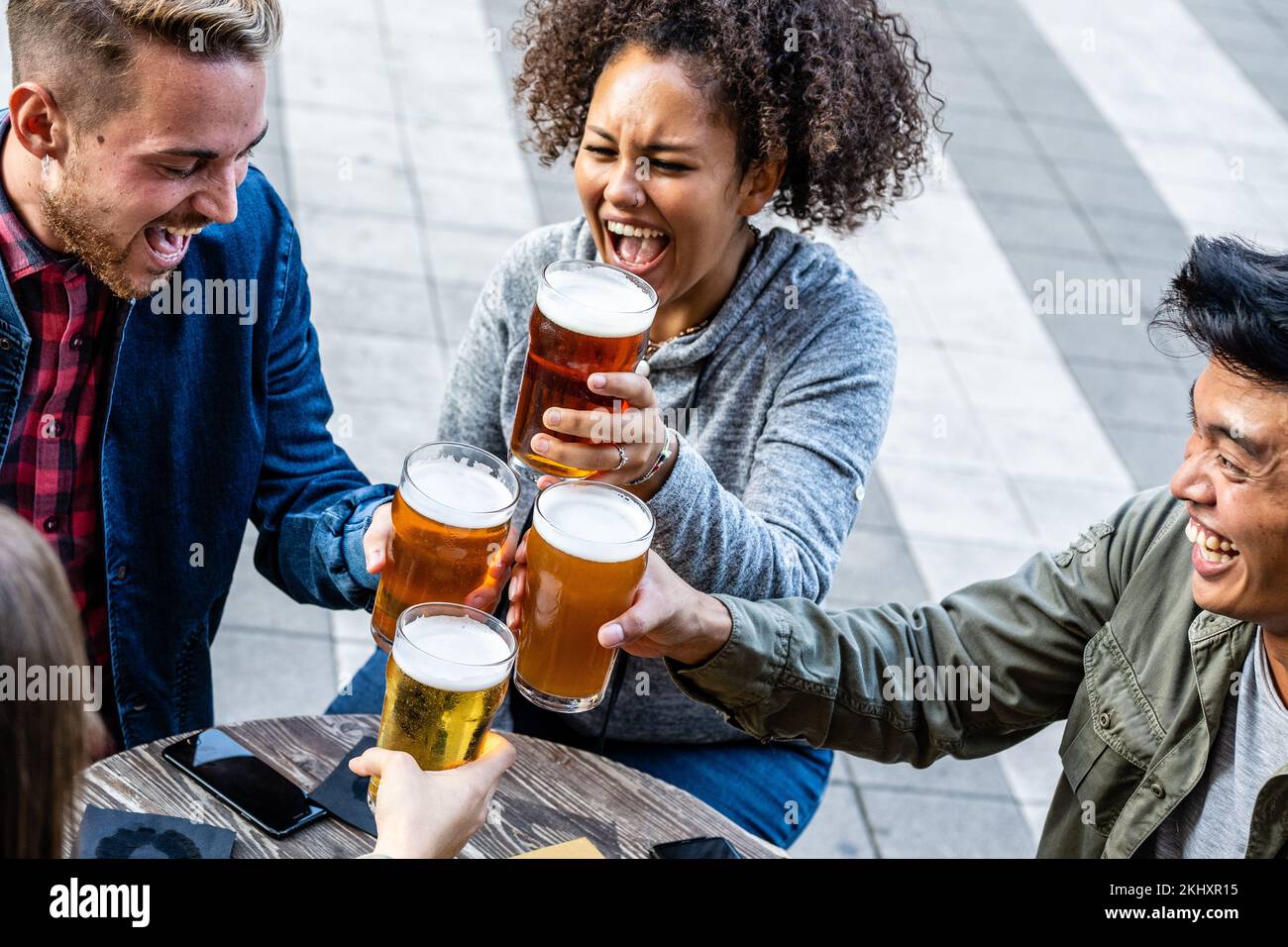 young people group toasting with pints of beer, generation z men and ...