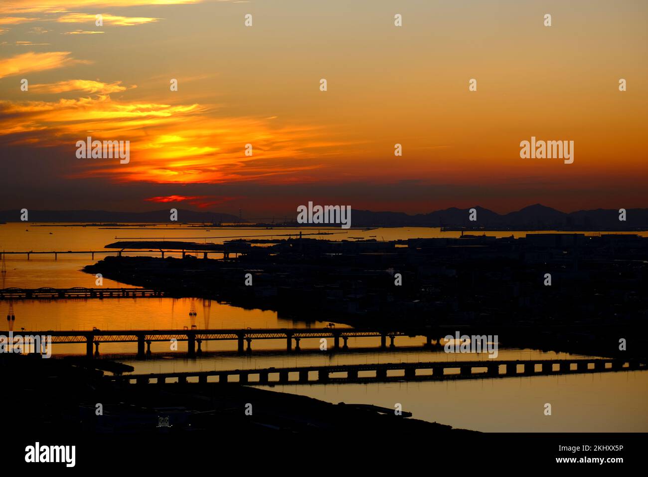 Setting sun obscured by clouds over Osaka Bay as viewed from the Sky ...