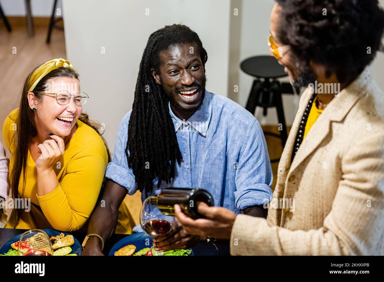 Toothy smile of group of multiracial friends dining at home, private ...