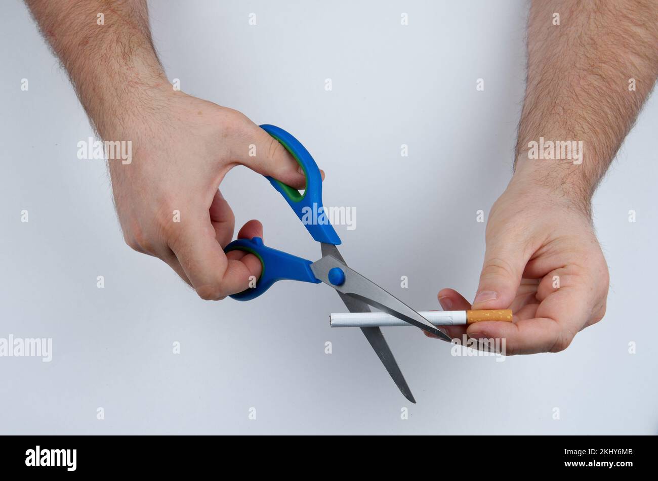 Quit smoking: hands with scissors cutting a cigarette Stock Photo - Alamy