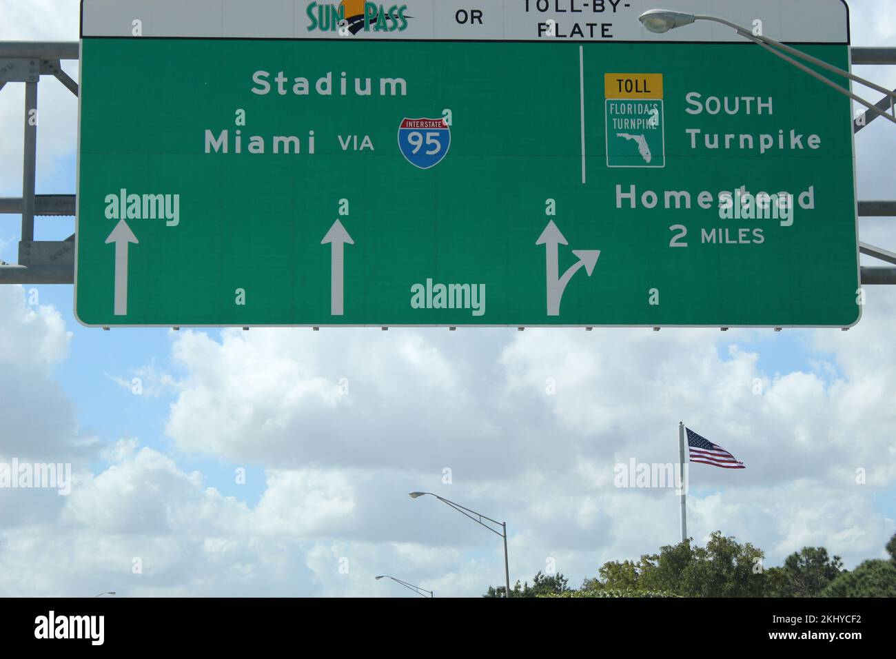 A Miami sign with an American flag waving underneath in the distance ...