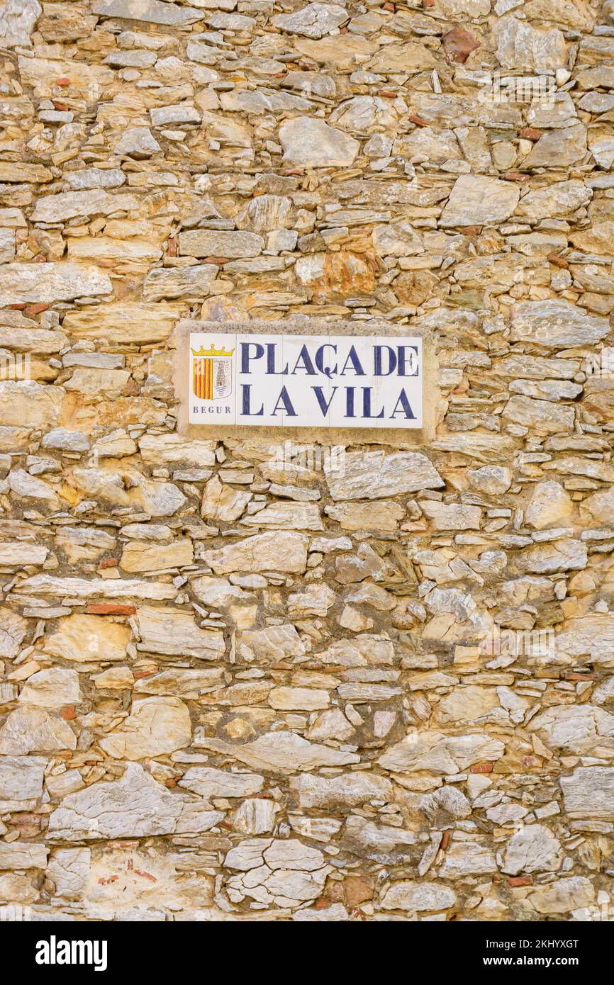 Placa de La Vila sign on old stone wall in the centre of Begur ...