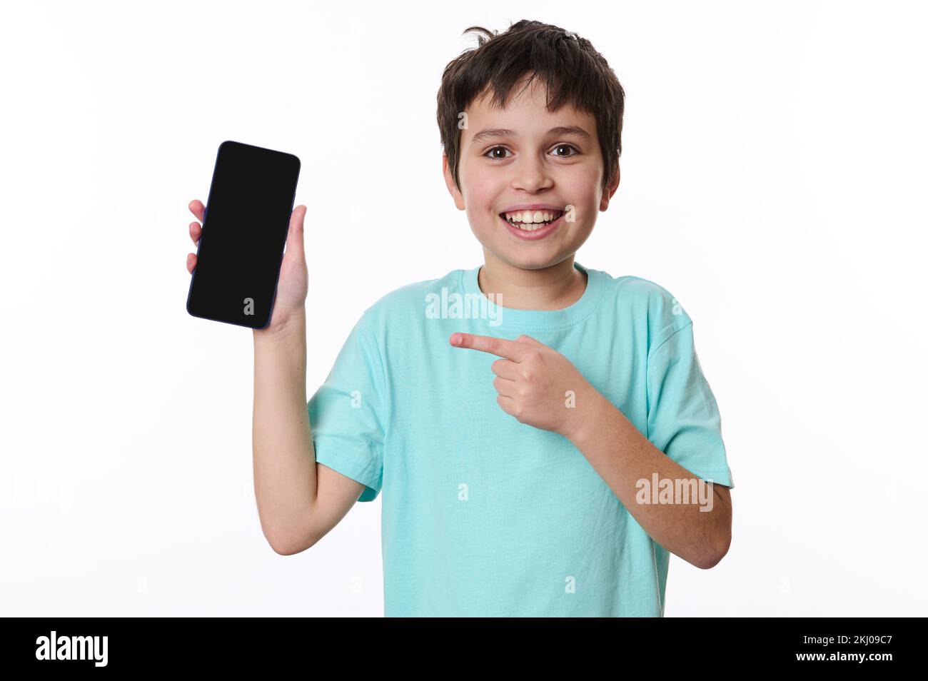 Awesome mobile app. Handsome teenage boy points at smartphone with ...