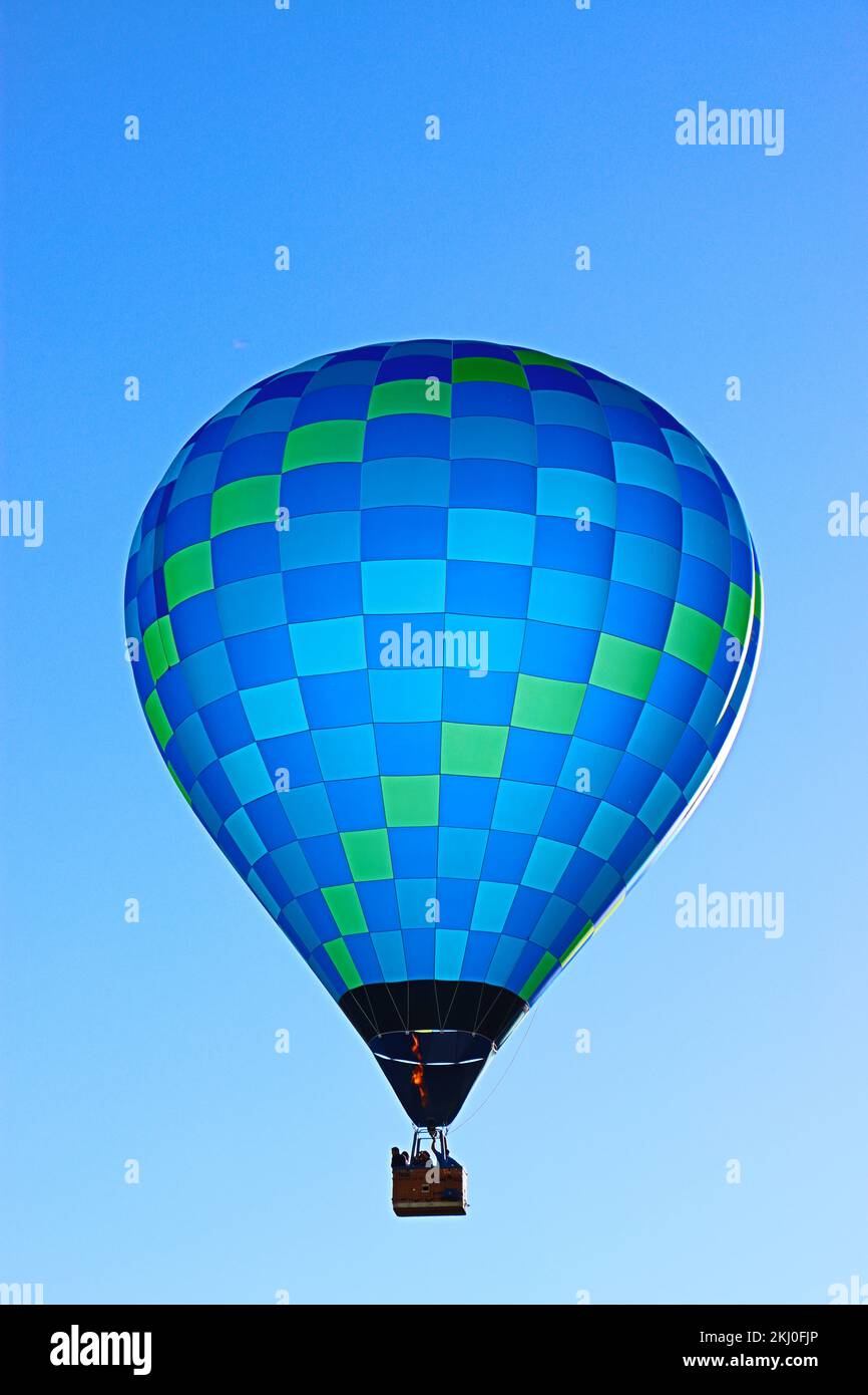 A vertical shot of a blue hot air balloon on a clear sky background ...