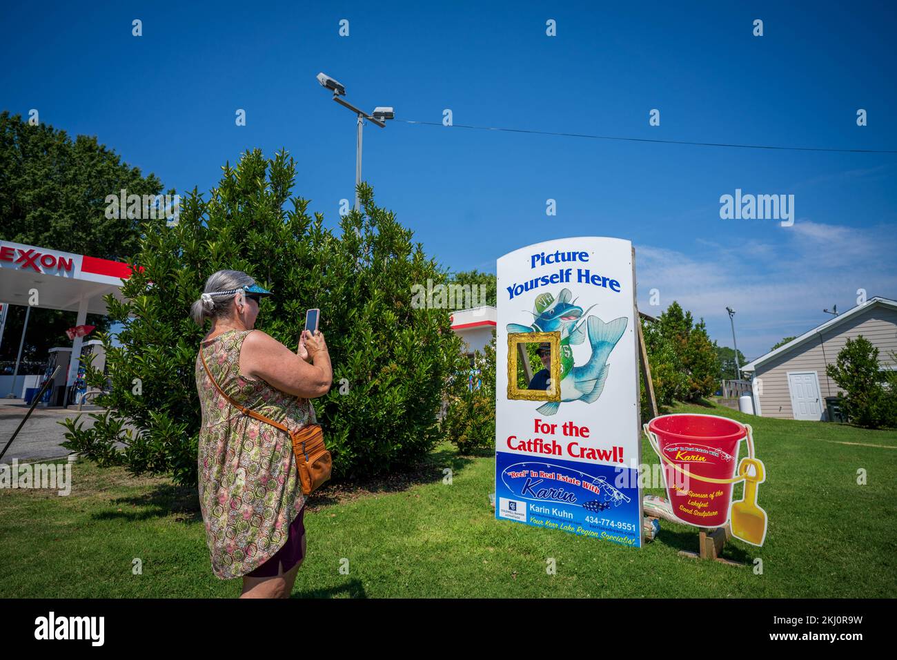 Picture yourself here sign with woman taking picture Stock Photo - Alamy