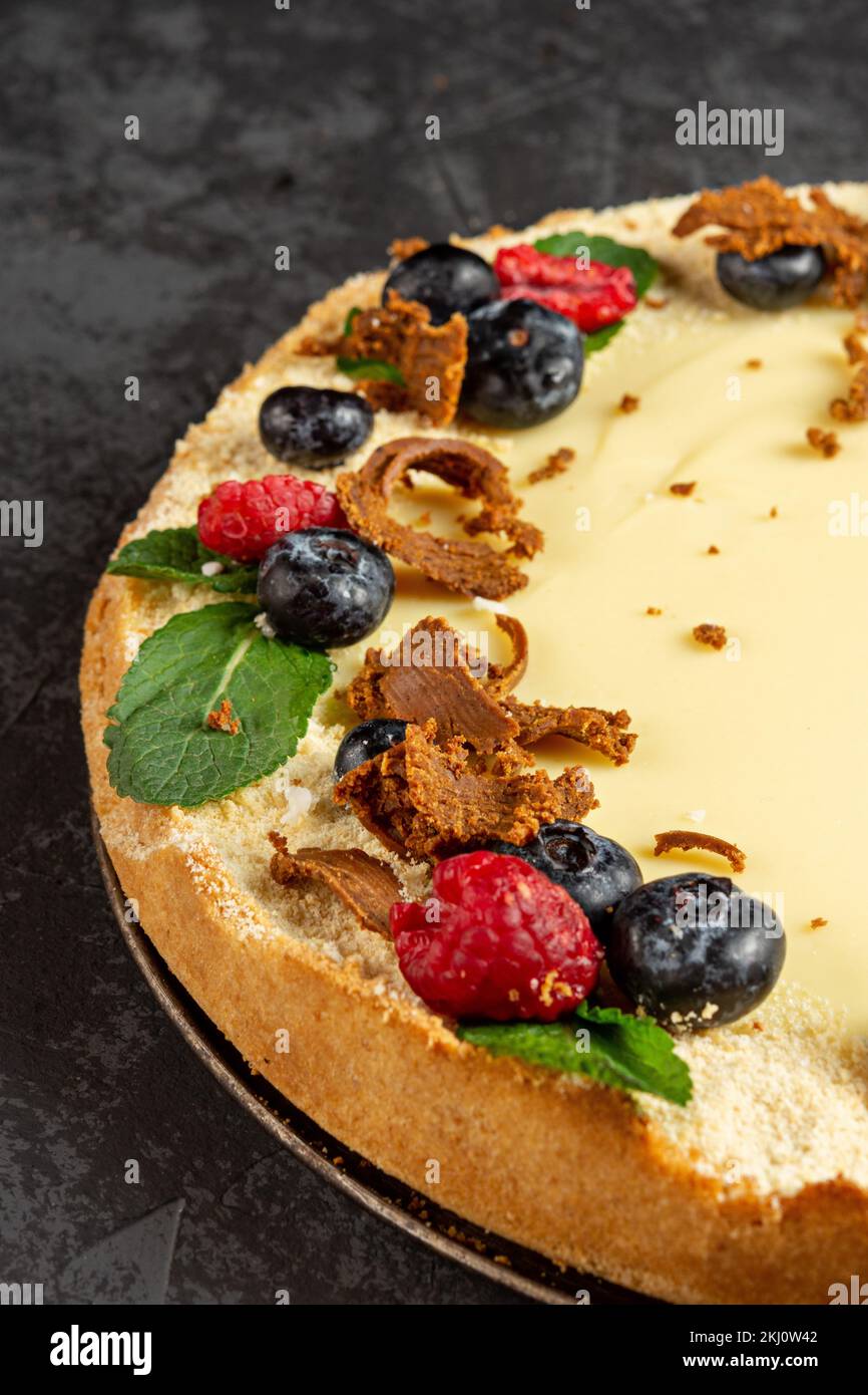 Homemade classic cheesecake on a dark background. Decorating a sweet ...
