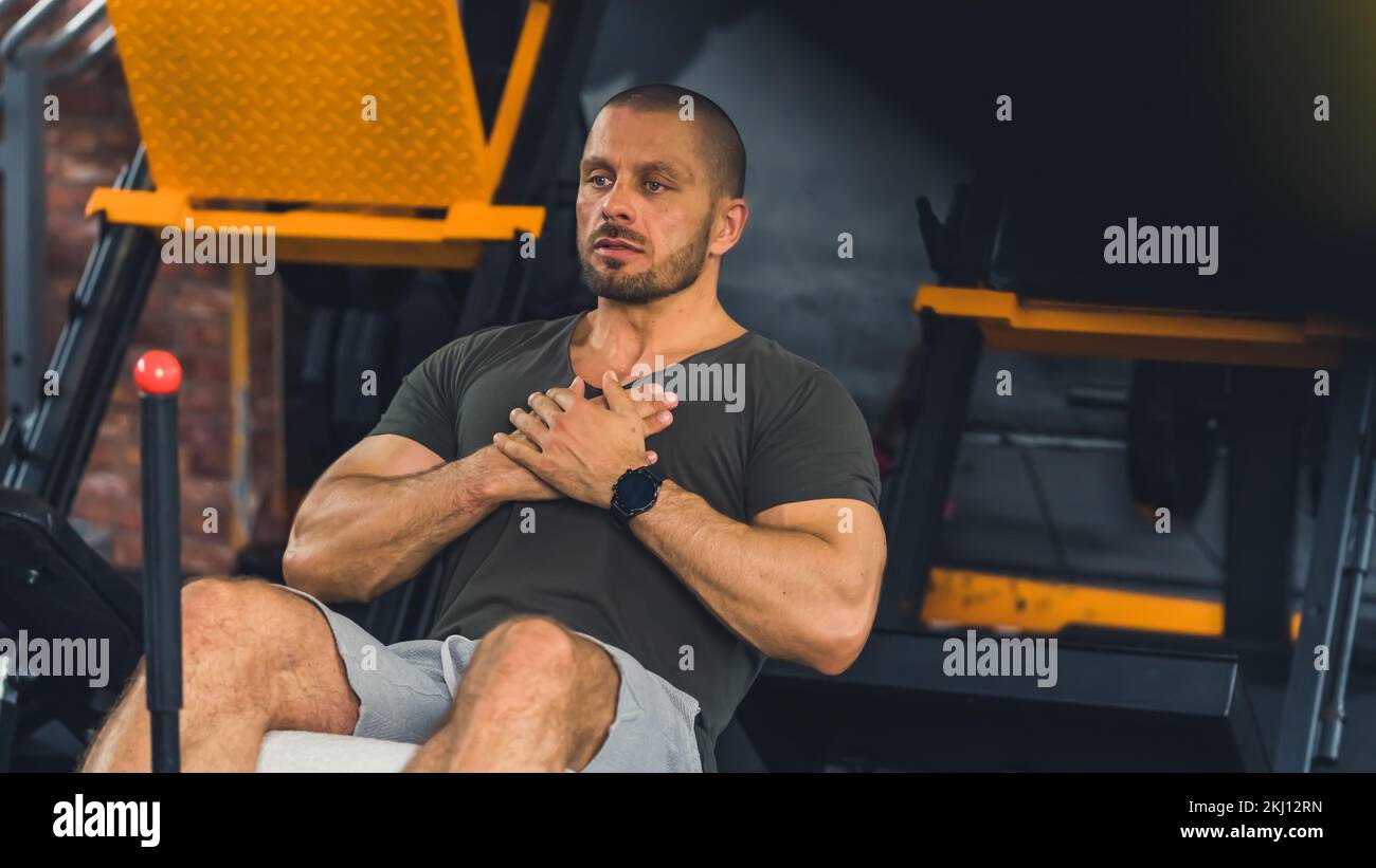 Strong, muscular, handsome bald man, bodybuilder, performing abs ...