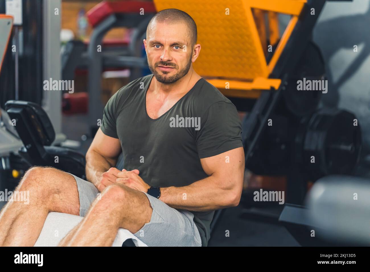 Strong, muscular, handsome bald man, bodybuilder, performing abs ...