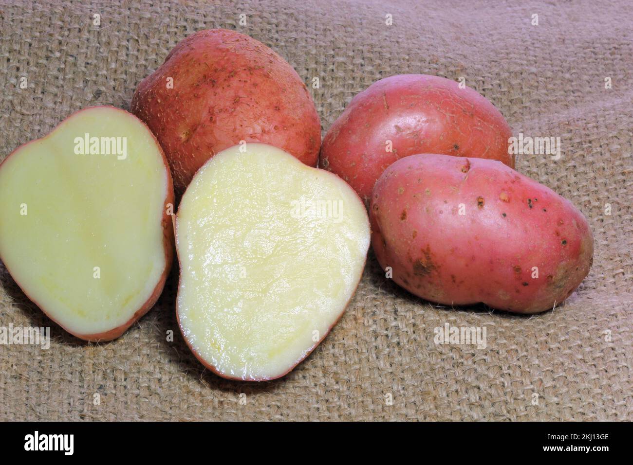 Raw red potatoes on a hessian background, potatoes cut in half Stock ...