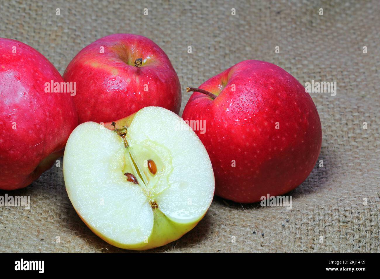 several red apples with one apple cut in half exposing the inside and ...