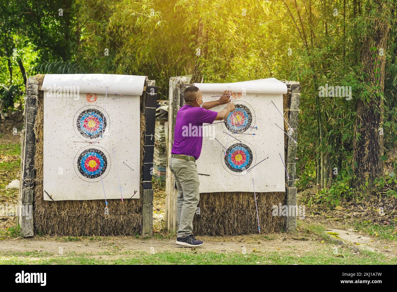 Back view of male officer wear face mask collect arrows fired from a ...