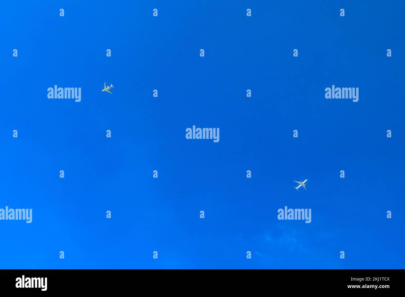 Two passenger commercial airplanes crossing flying, isolated in the ...