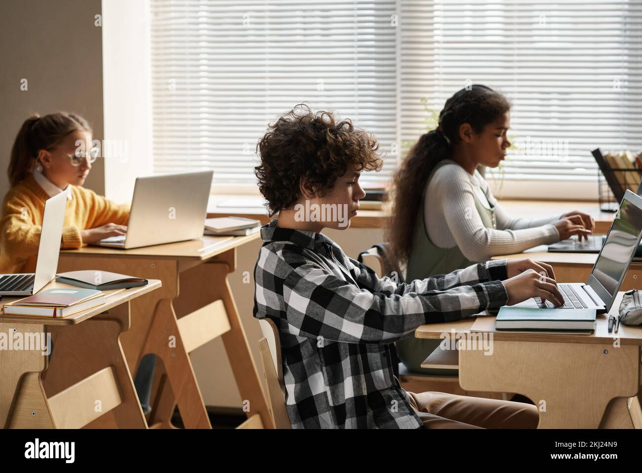 Group of children learning to work with computer program during IT ...