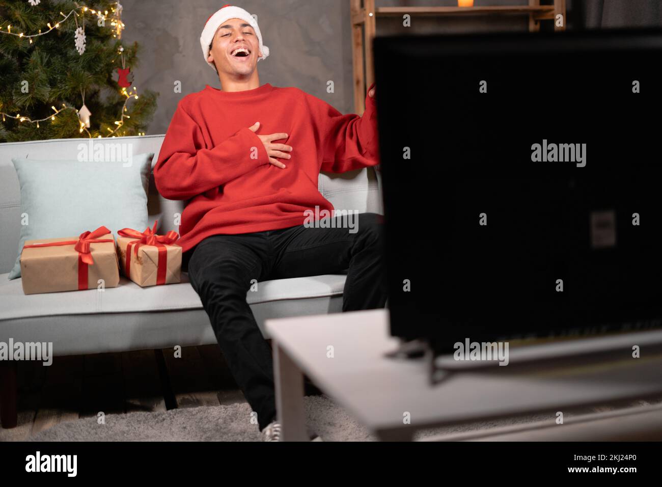 Home cinema, a guy watching a comedy at Christmas laughing and ...