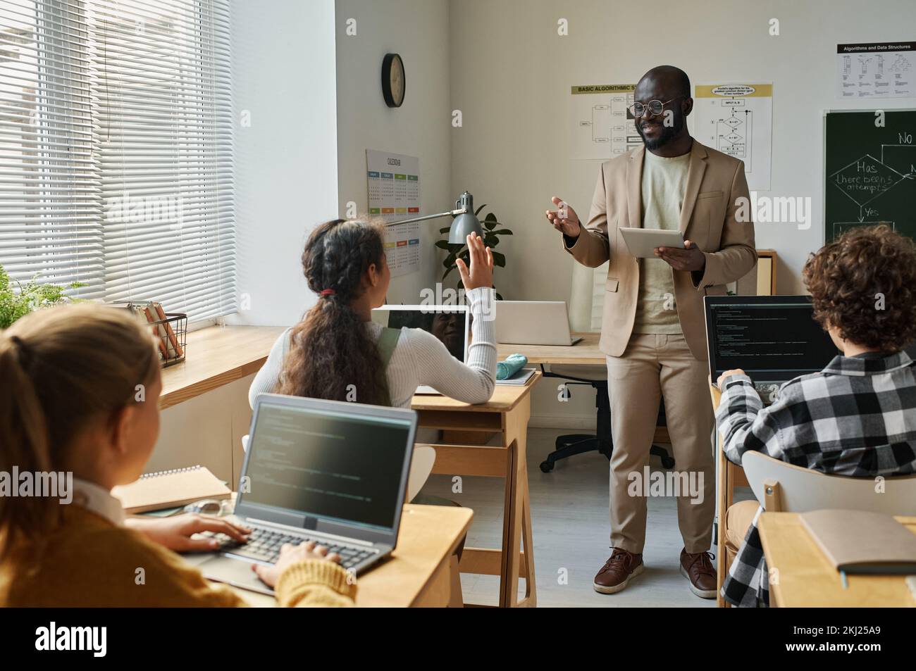 African American teacher using tablet pc to teach children information ...