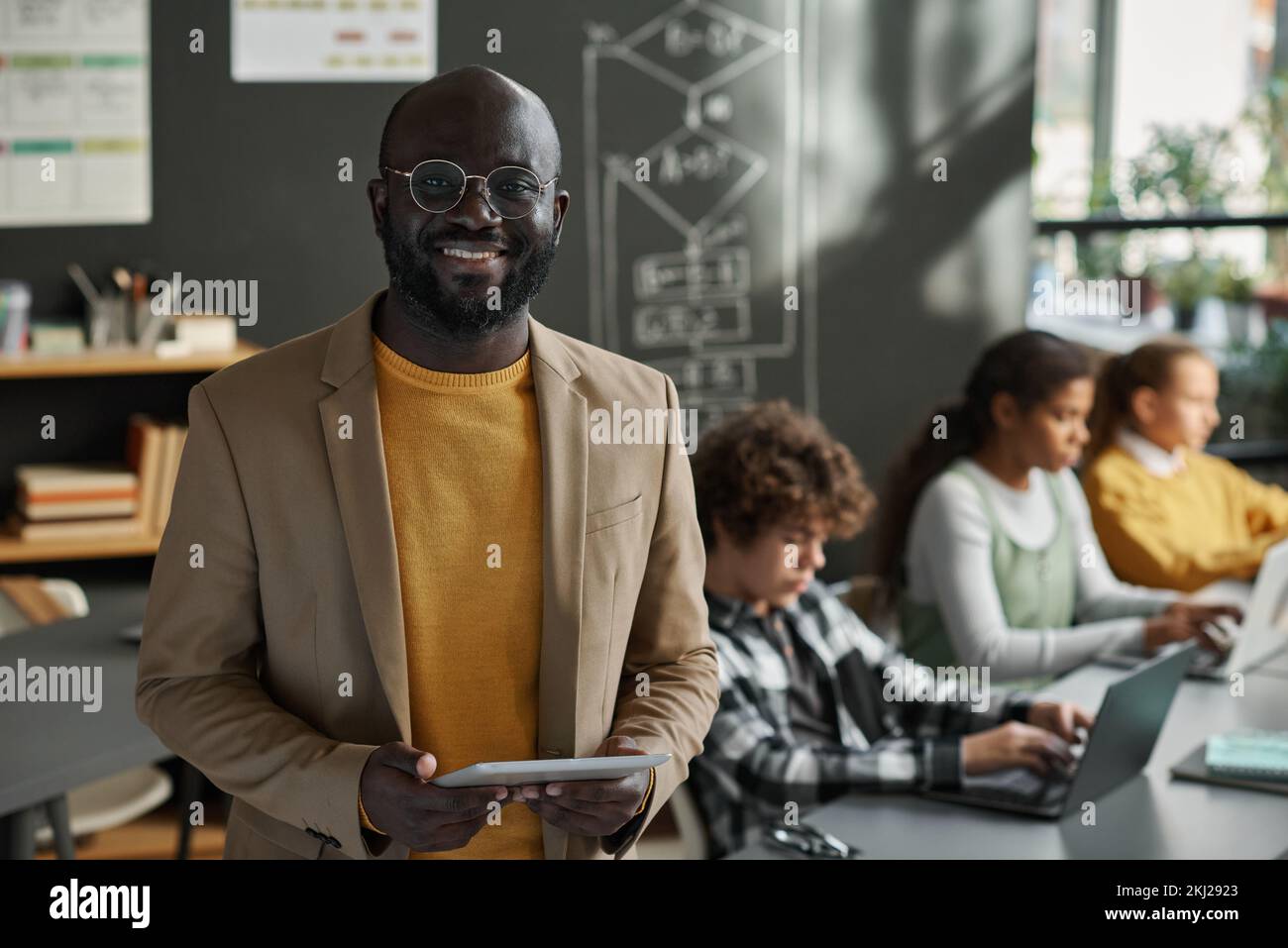 Portrait of African American IT teacher smiling at camera standing in ...