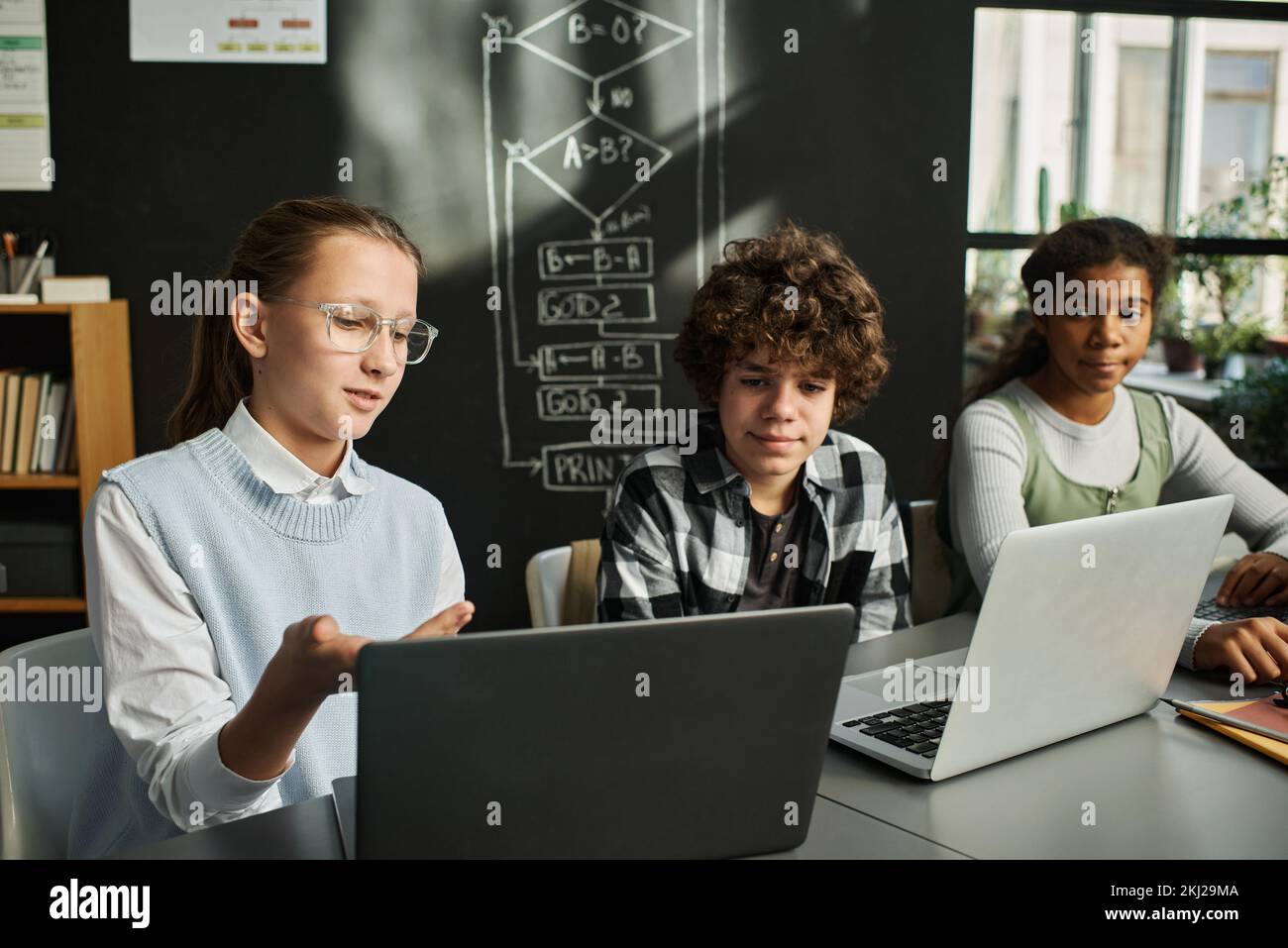 Group of children discussing new software together on computer while ...