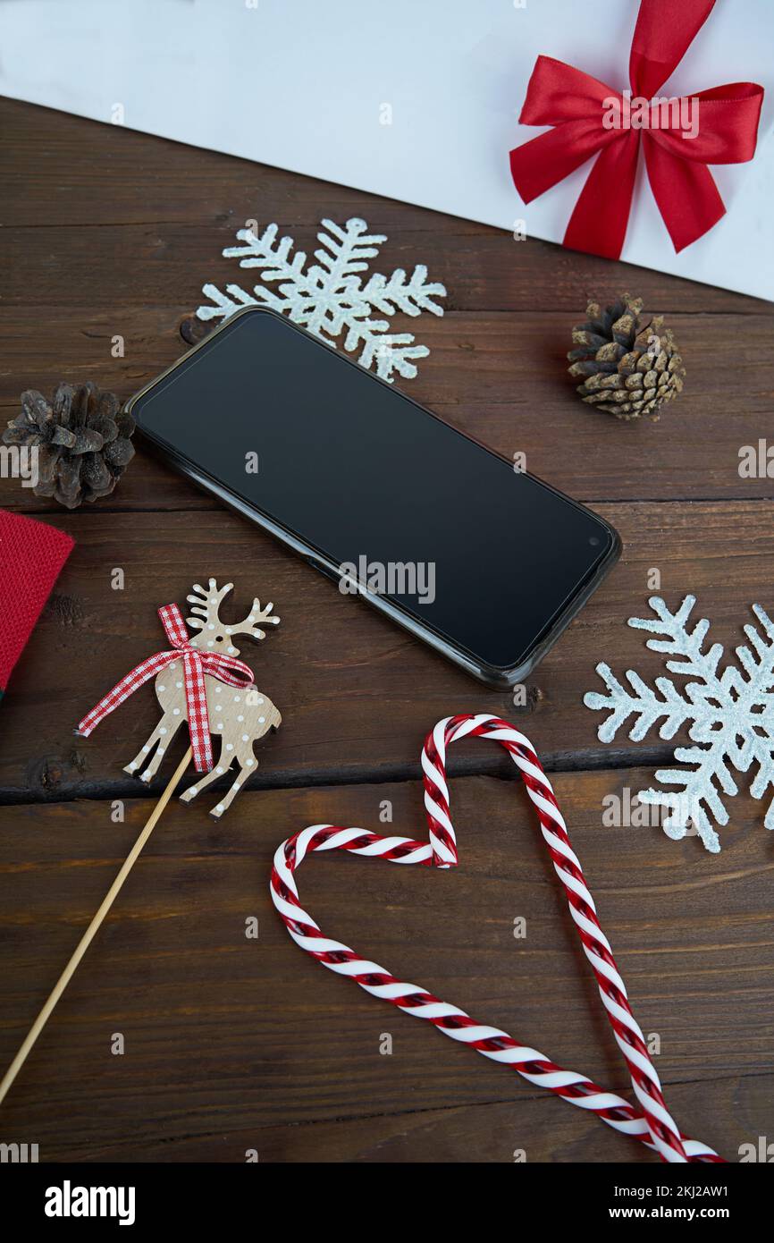 A cellphone, pinecone, reindeer, snowflakes and two candy cane forming ...