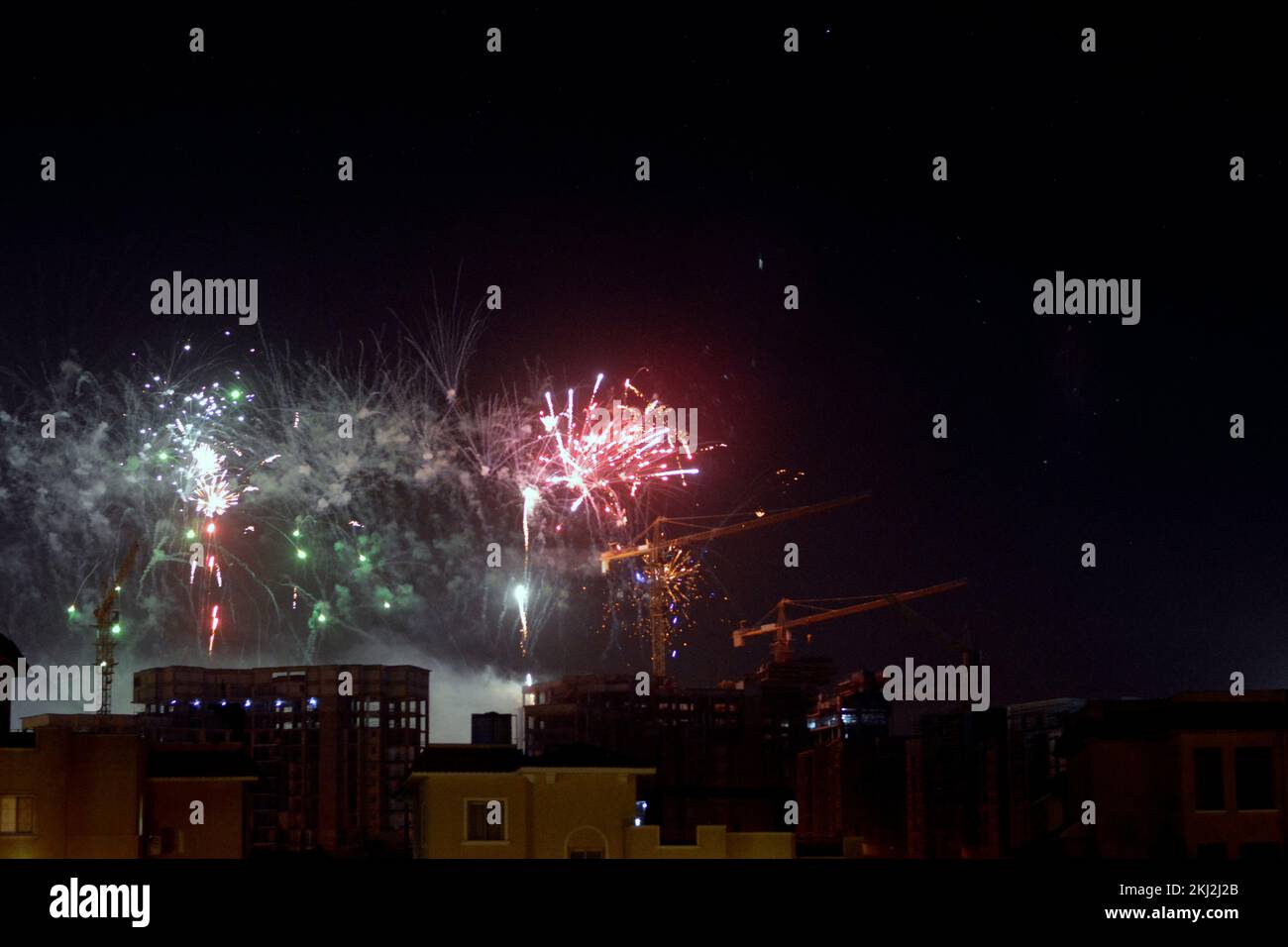 colorful fireworks at night with shadows of a construction site and ...