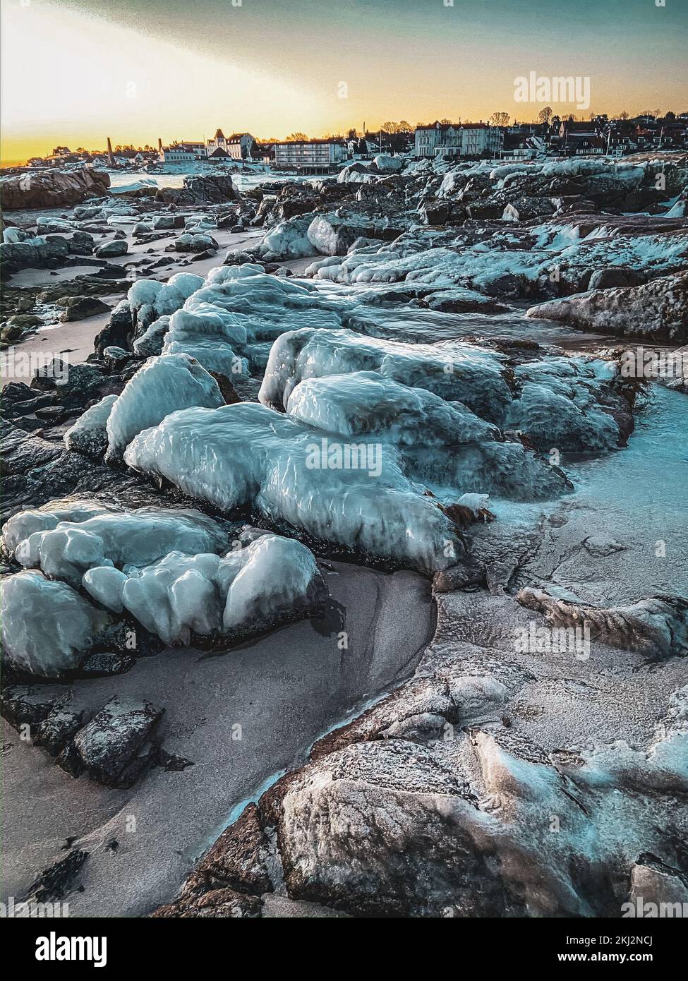 A vertical closeup of icy sand dunes at sunrise, golden clear sky ...
