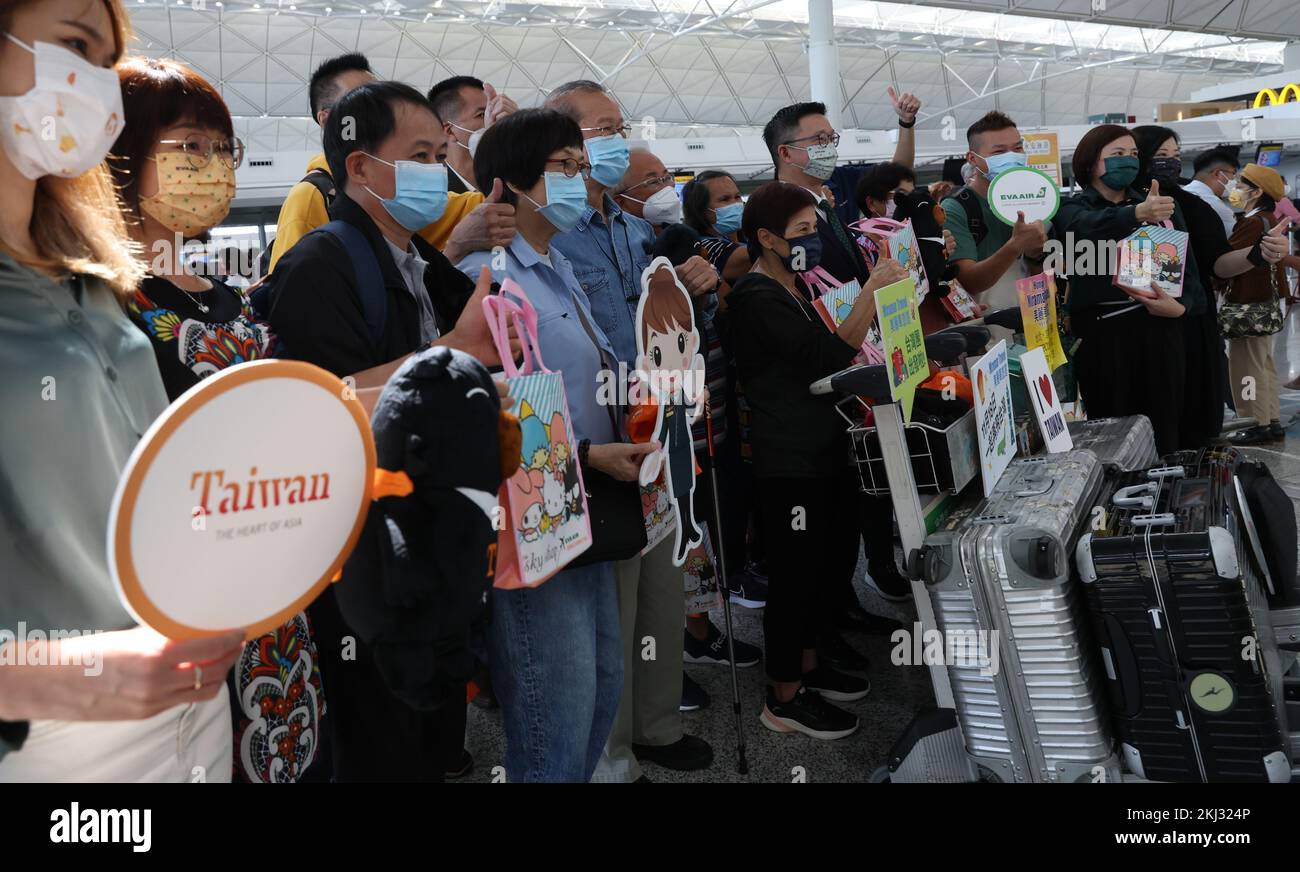 Passengers pose for a picture at the EVA Airways counter in Hong Kong ...