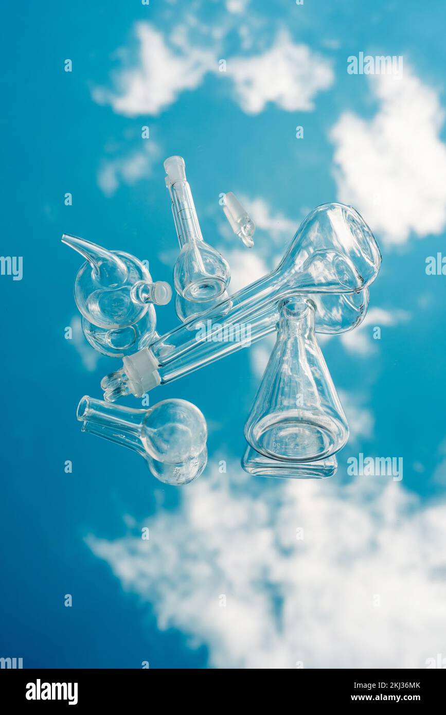 Various laboratory glassware on a mirror background with sky reflection ...