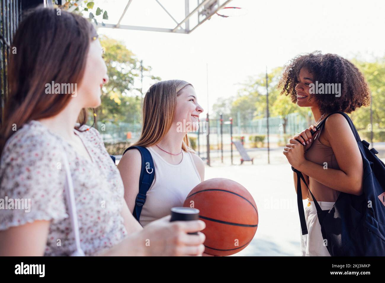 Multicultural group of young female friends bonding outdoors and having ...