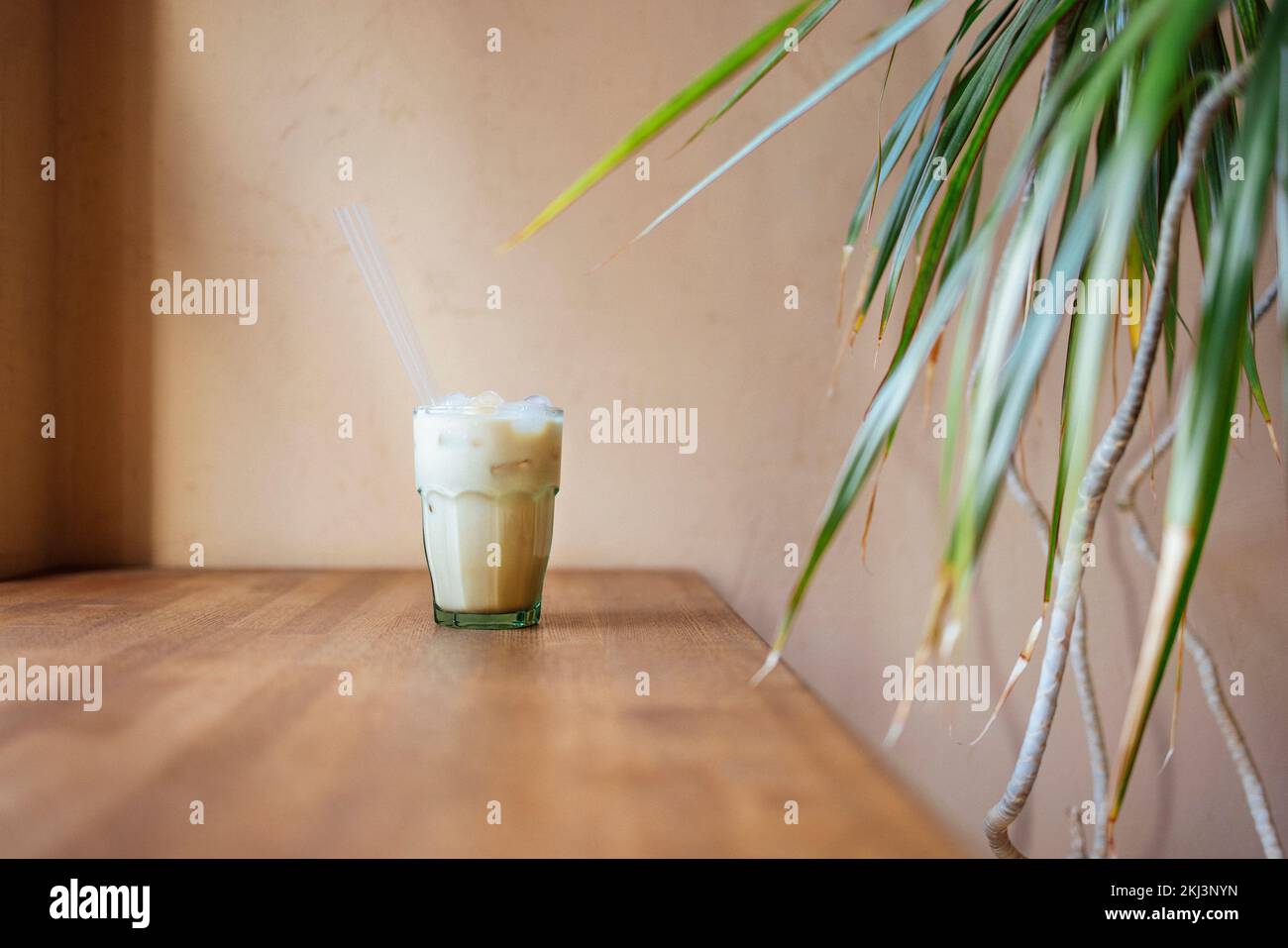 Iced coffee latte in a tall glass with caramel and chocolate syrup and ...