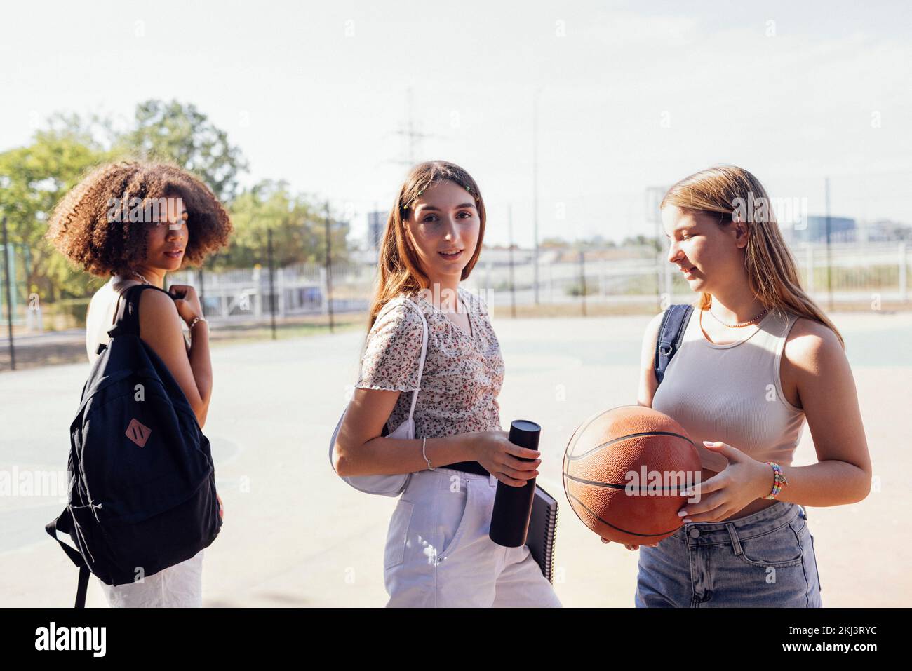 Multicultural group of young female friends bonding outdoors and having ...