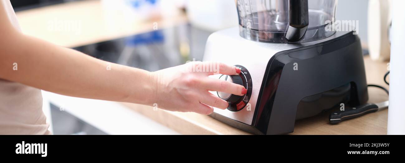 Woman turns on mixer for mixing products closeup Stock Photo - Alamy