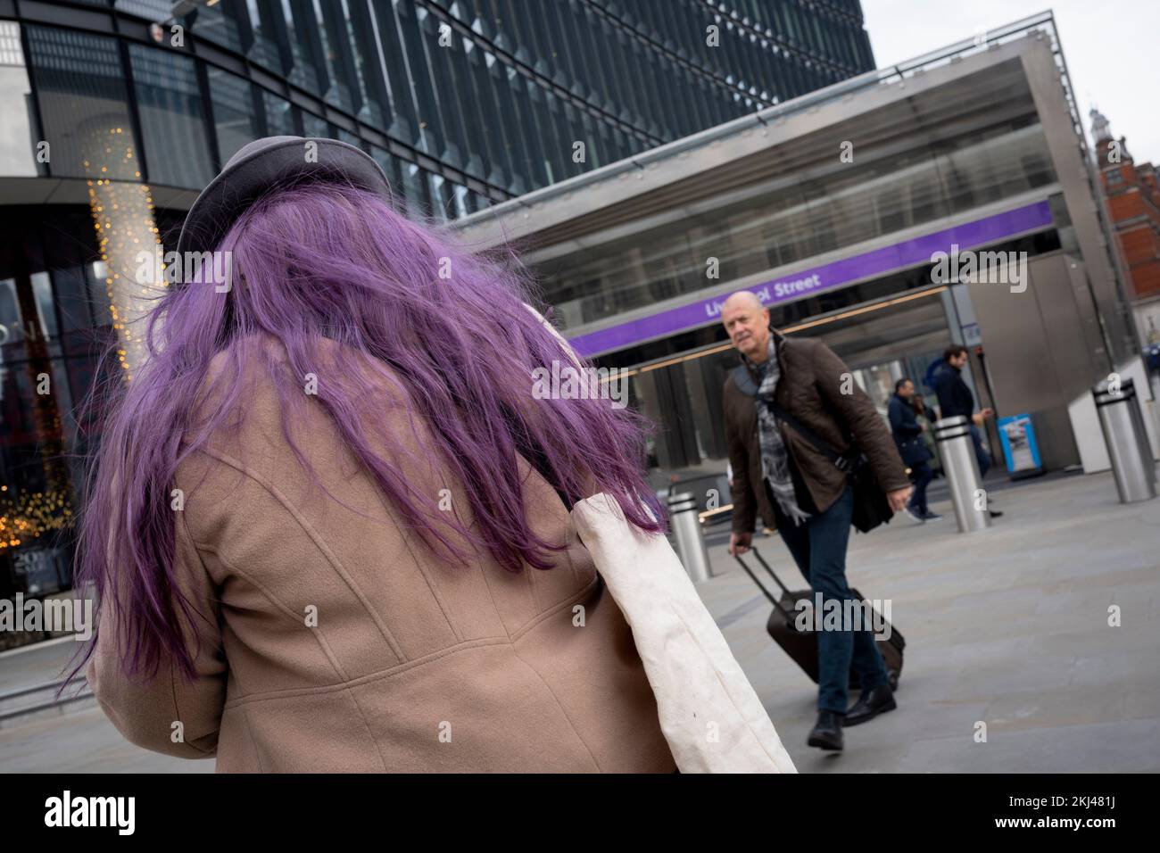 A rear view of a woman whose purple hair matches the branded colour of ...